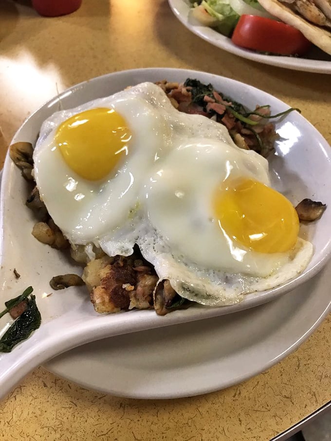 Two eggs perched atop a savory medley of mushrooms and potatoes – proof that sometimes the best views at an airport aren't through the windows.