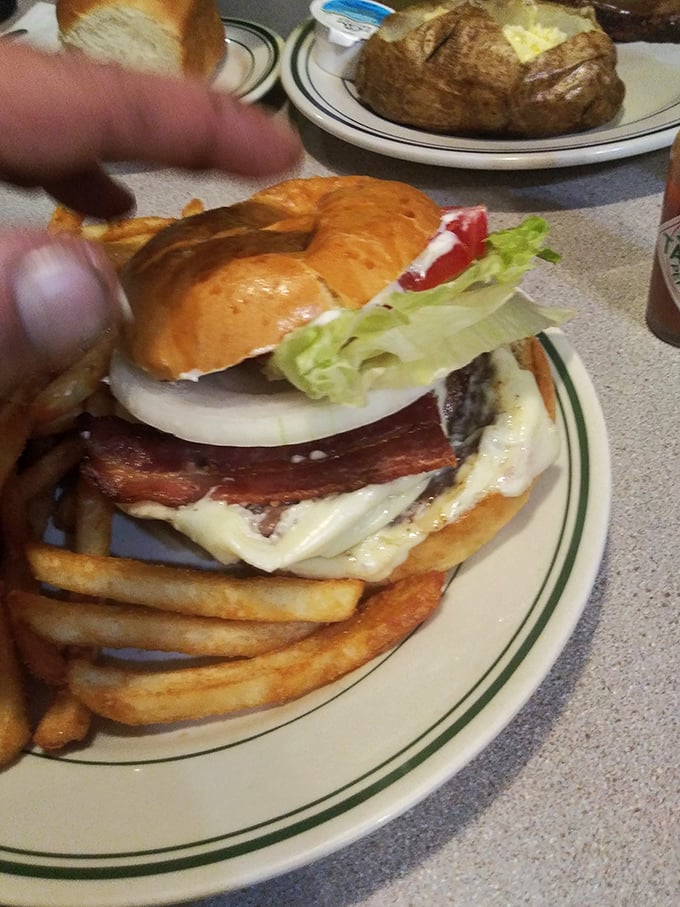 This isn't just a burger—it's architecture. The bacon's hanging off the edge like it's showing off, and rightfully so.
