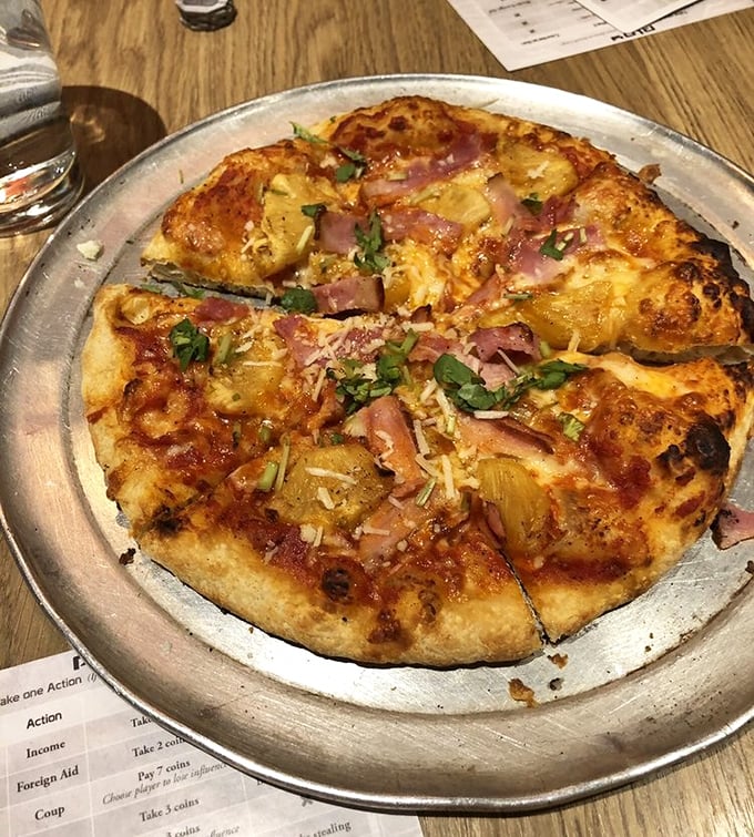 Hawaiian pizza reimagined: caramelized pineapple and ham on a perfectly charred crust that would make even pizza purists reconsider their stance.