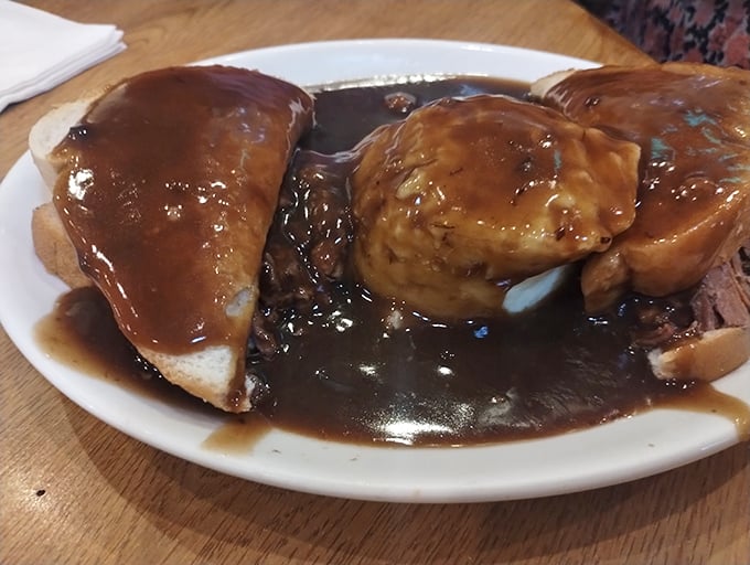 The hot beef sandwich—where gravy isn't just an addition, it's practically a philosophy. Fork required, napkins essential, afternoon nap highly recommended.