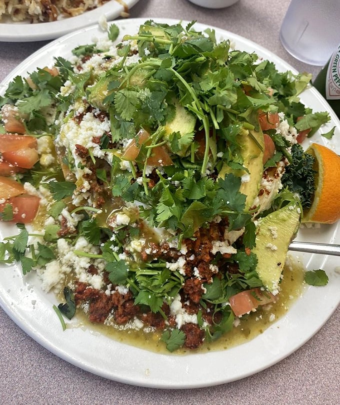 This isn't just Huevos Rancheros—it's a fiesta on a plate where cilantro confetti rains down on avocado mountains and chorizo valleys.