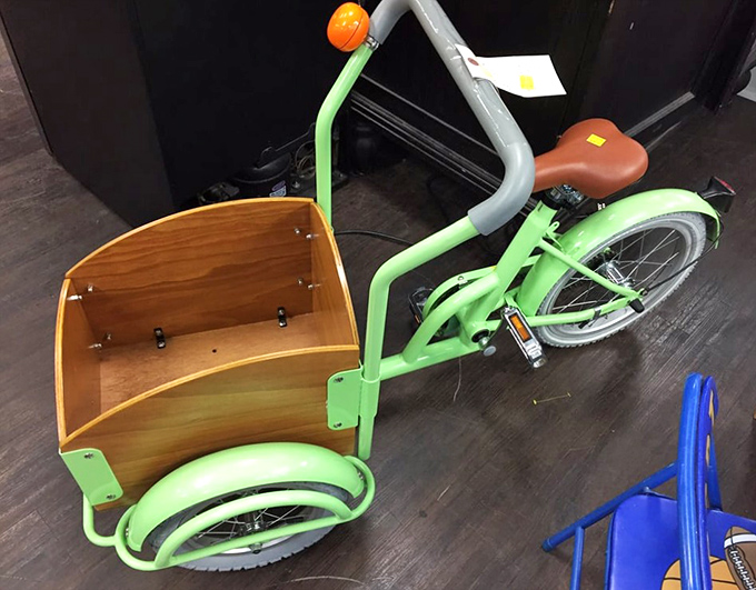 This lime-green cargo tricycle isn't just transportation—it's childhood joy on wheels, ready for its next adventure with a lucky kid.