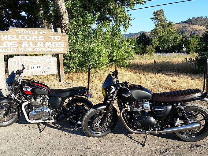 Two motorcycles rest at the town's entrance sign—modern-day horses for travelers exploring "The Valley of the Cottonwoods."