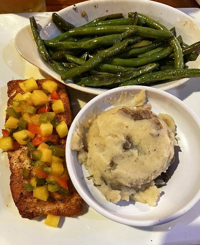 Mango salsa dancing atop perfectly seared salmon with green beans and mashed potatoes that didn't come from a box – comfort food elevated.