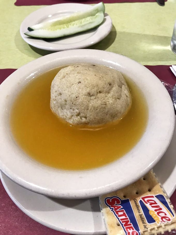 The matzo ball soup – where a perfect dumpling floats like the moon in a golden broth universe that could cure anything from colds to existential crises.