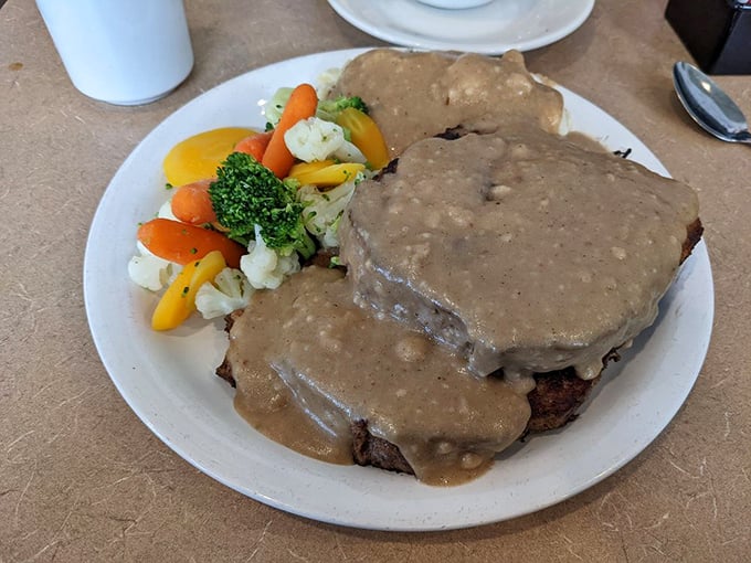 Country-style meatloaf smothered in gravy that your grandmother would approve of, served with vegetables to maintain the illusion of balance.