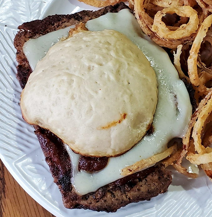 This isn't just a burger—it's a testament to the power of melted cheese and perfectly seasoned beef. The crispy onion rings are the supporting actors who steal the show.
