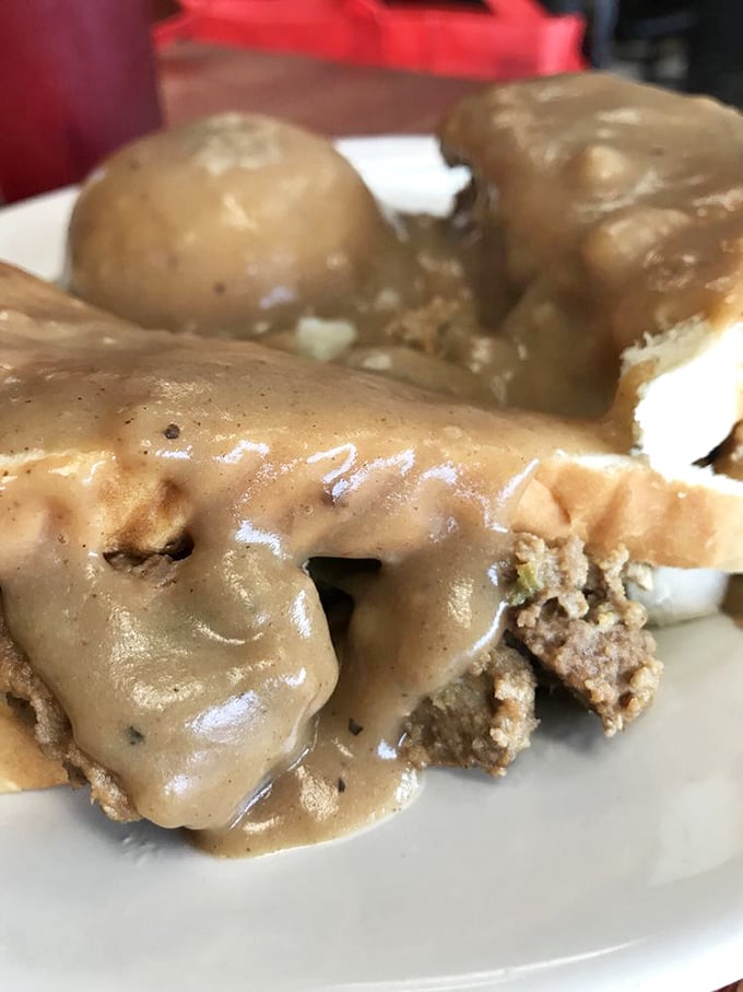 Comfort on a plate – savory meatloaf sandwich swimming in gravy that's clearly been simmering since before your morning alarm went off.