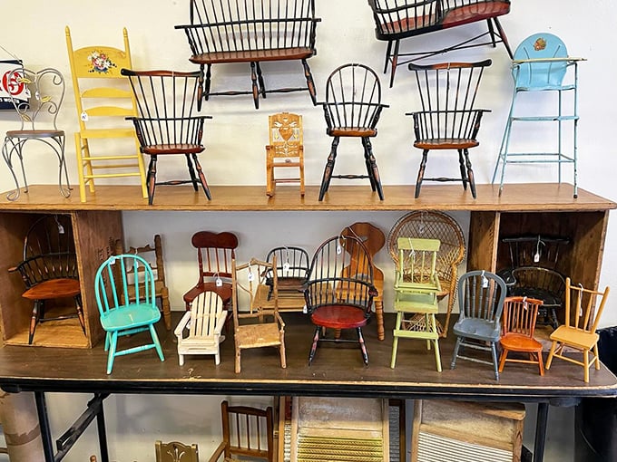 A miniature chair convention where no one sits down—each tiny seat telling its own story of craftsmanship and design.