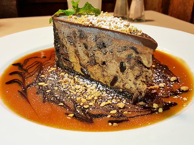 This mud pie isn't playing around—layers of chocolate decadence swimming in caramel sauce with a sprinkle of nuts for that perfect textural crescendo.