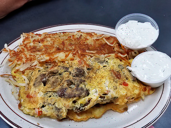 An omelet that doesn't just sit on the plate—it commands attention with its perfectly browned exterior hiding treasures within.