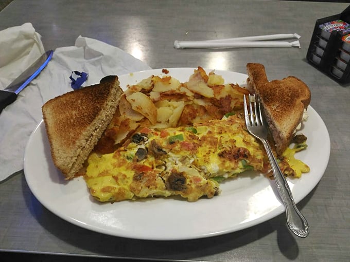 Breakfast artistry in action—this veggie-packed omelet with perfectly golden home fries proves morning meals deserve serious culinary respect.