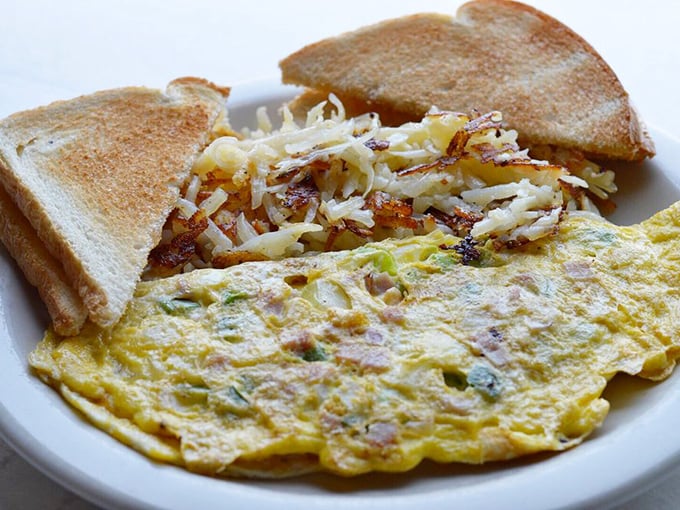 This omelet has that perfect yellow glow, with hash browns so crispy they practically audition for their own cooking show.
