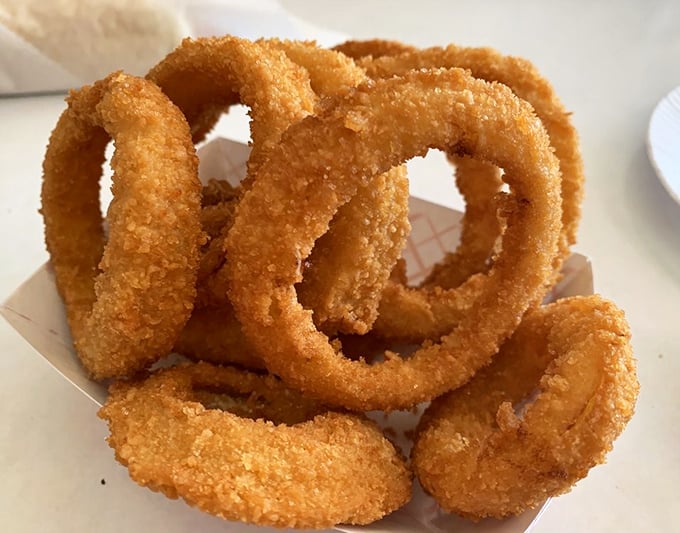 Golden onion rings stacked like delicious jewelry—crispy, light, and worth every calorie-laden bite.