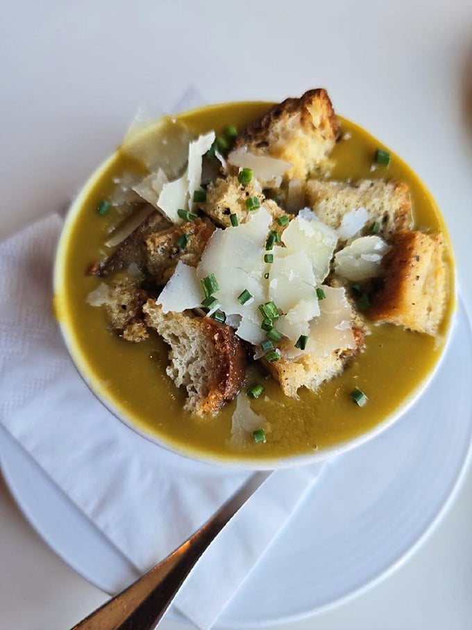A golden split pea soup crowned with croutons and Parmesan shavings—comfort food that somehow manages to feel sophisticated.
