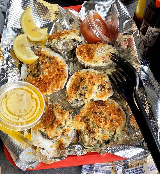 Oysters Rockefeller on foil – unpretentious presentation for a dish that lets the briny-sweet flavors take center stage.