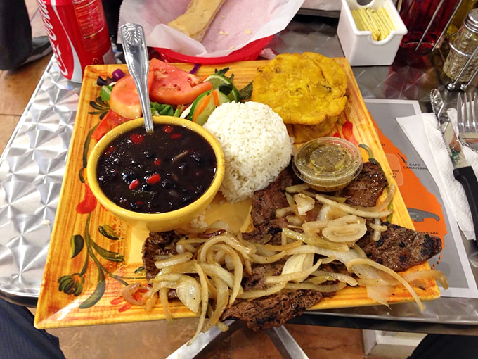 Palomilla steak with all the fixings. Thin-cut beef topped with sautéed onions, served alongside beans darker than midnight and rice whiter than South Beach sand.
