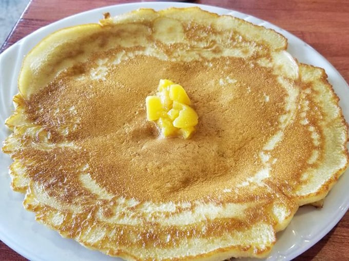 This pancake could double as a dinner plate – thin, buttery, and wide enough to require strategic fork planning.