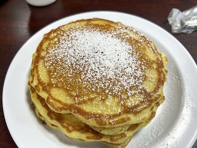 Classic pancakes dusted with powdered sugar – sometimes the simplest pleasures are the most satisfying. Maple syrup application is your artistic choice.