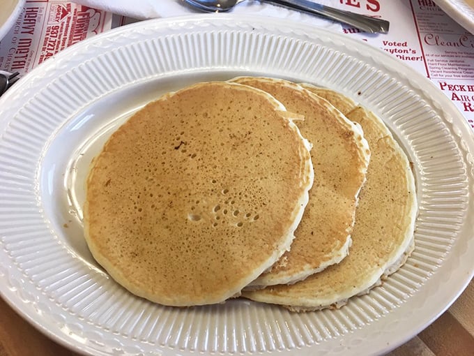 These golden pancakes aren't just breakfast, they're edible sunshine – perfectly round with that ideal balance of fluff and substance.