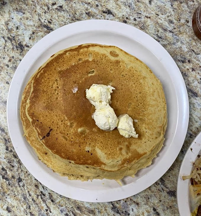 Golden-brown pancake perfection with a dollop of butter slowly melting into those fluffy layers—breakfast doesn't get more hypnotic than this.
