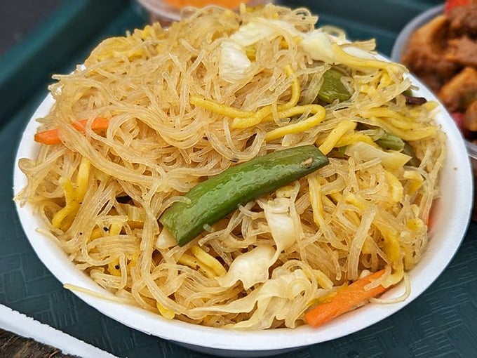 This isn't just noodles; it's pancit – a tangle of translucent vermicelli dancing with vegetables that puts your sad desk lunch to shame.