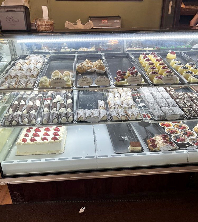 The display case – where dreams and diets go to negotiate terms. Each perfectly arranged pastry is a small masterpiece waiting for its moment.