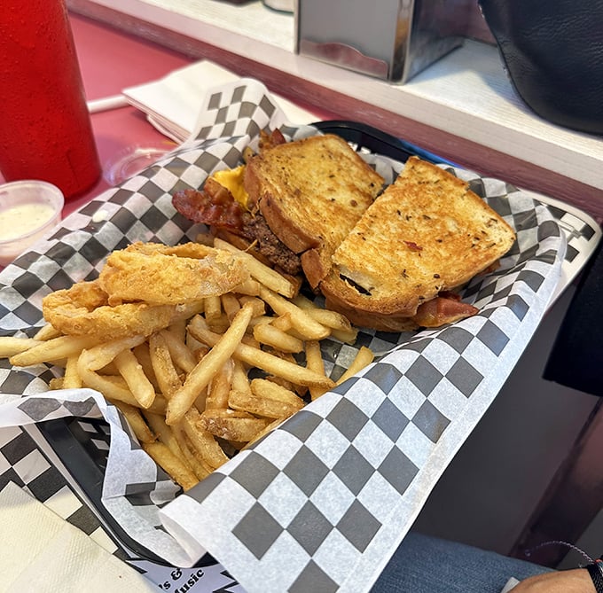 The patty melt—that magical union of beef, cheese, and grilled bread—served with a side of fries that look like they're auditioning for a food commercial.