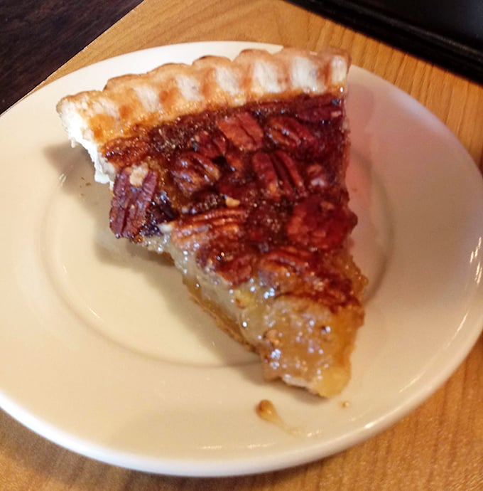 This slice of pecan pie isn't just dessert, it's Southern comfort in triangular form—the kind of sweet finale that makes you loosen your belt with zero regrets.