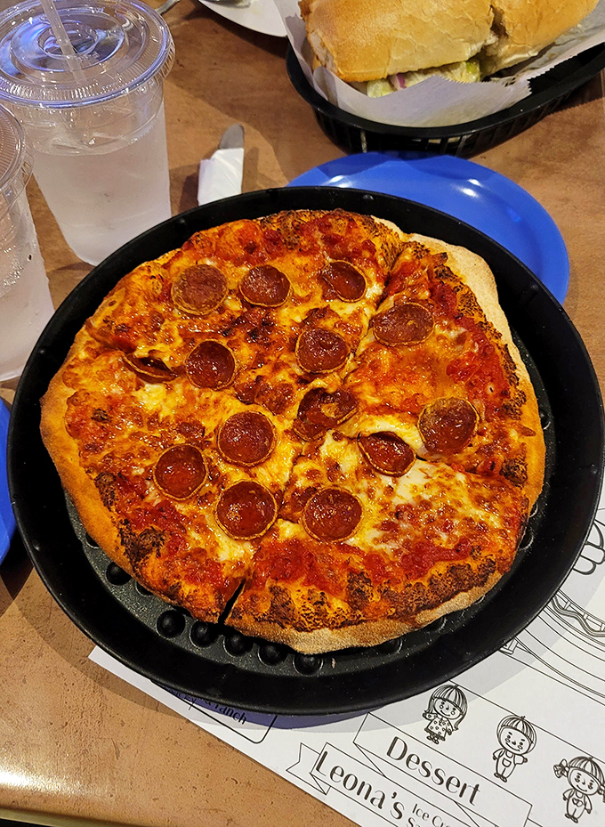 Pizza perfection in cast iron – those crispy-edged pepperoni cups holding tiny pools of flavor are what food dreams are made of.