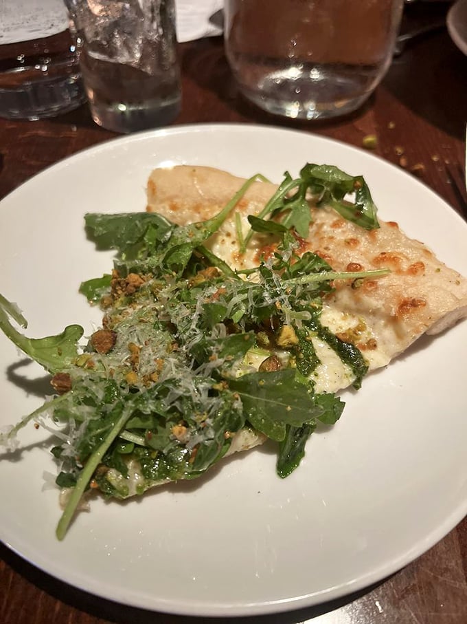 A white pizza topped with arugula that somehow makes you feel virtuous while indulging in cheese-laden bliss.