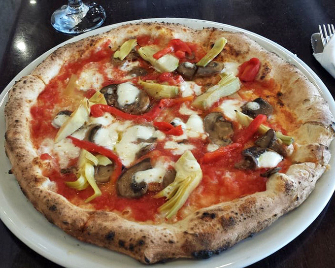 Pizza perfection isn't just about toppings – it's that magical marriage of mushrooms, artichokes and cheese on a crust that's both cloud and canvas.