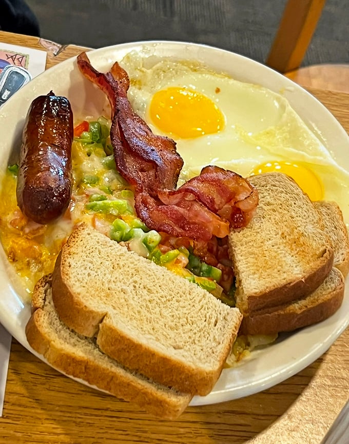 The breakfast of champions—eggs, sausage, bacon, and toast arranged like a painter's palette of morning delights.