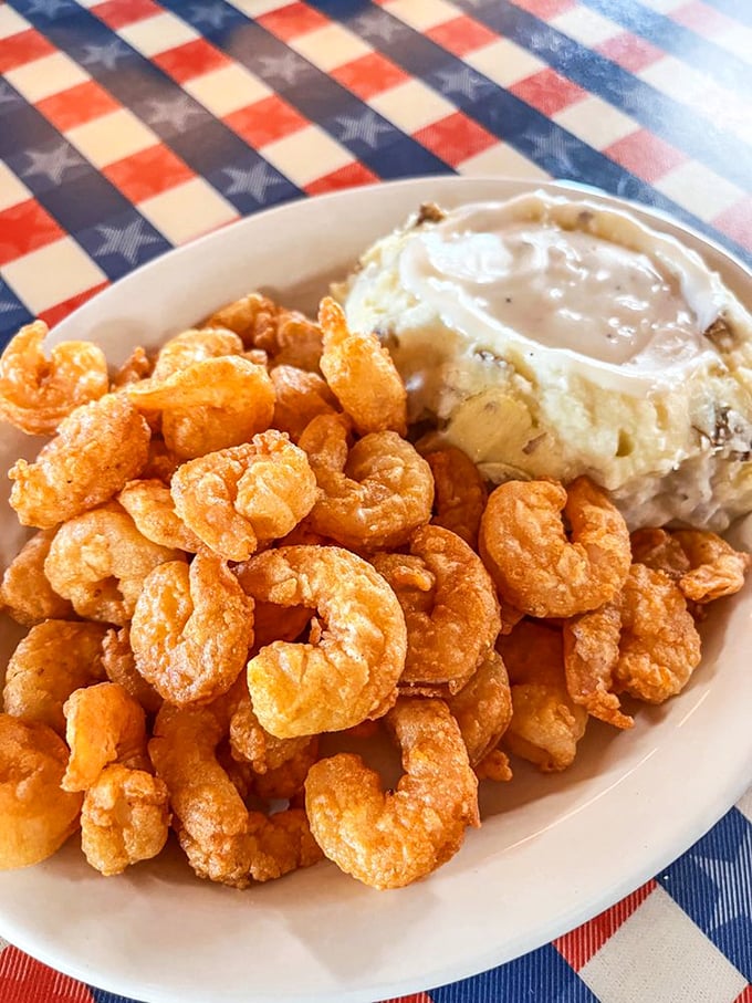 A mountain of golden popcorn shrimp alongside creamy mashed potatoes—proof that sometimes the best things in life come in small, crispy packages.