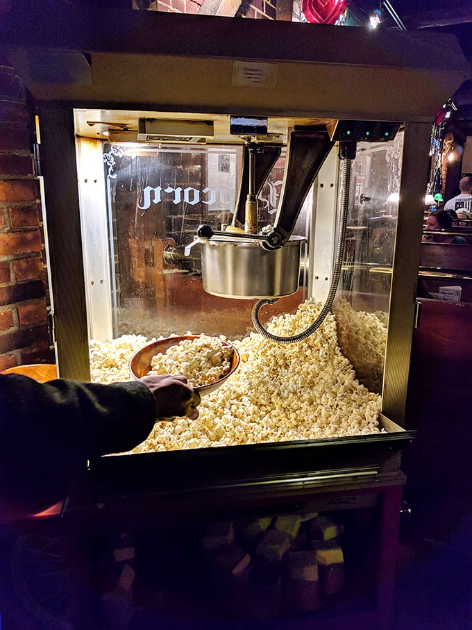 Fresh popcorn being scooped from an old-school machine – because sometimes the simplest pleasures make the perfect bar companion.