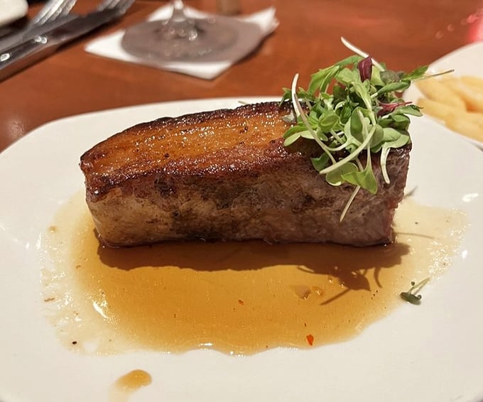 This isn't just steak—it's meat architecture. Perfectly seared, resting in its own glorious juices, topped with microgreens pretending to make it healthy.
