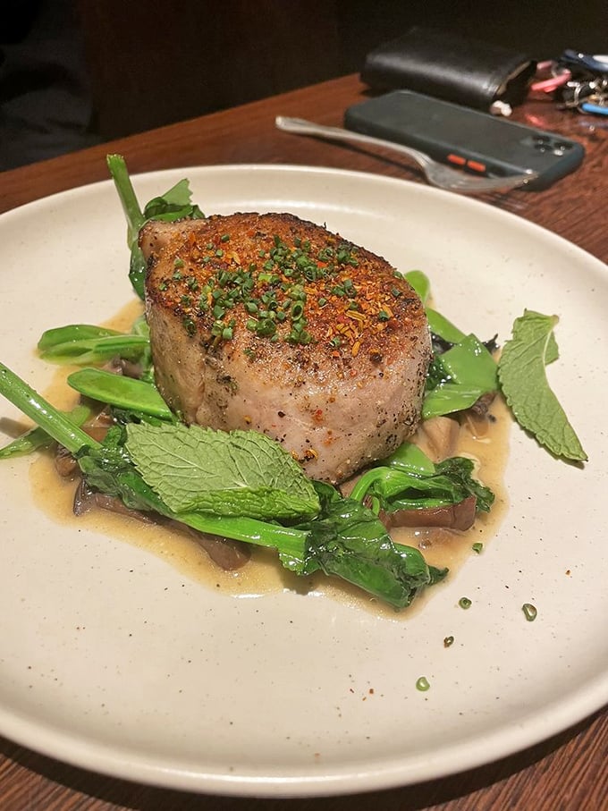 This isn't just a pork chop—it's pork elevated to its highest calling. Nestled on a bed of greens with a sauce you'll be tempted to drink straight.
