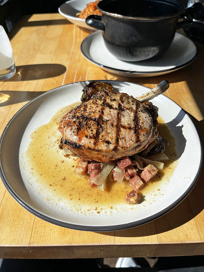 Not just a pork chop – it's a bone-in masterpiece swimming in a sauce that would make even vegetarians consider conversion.