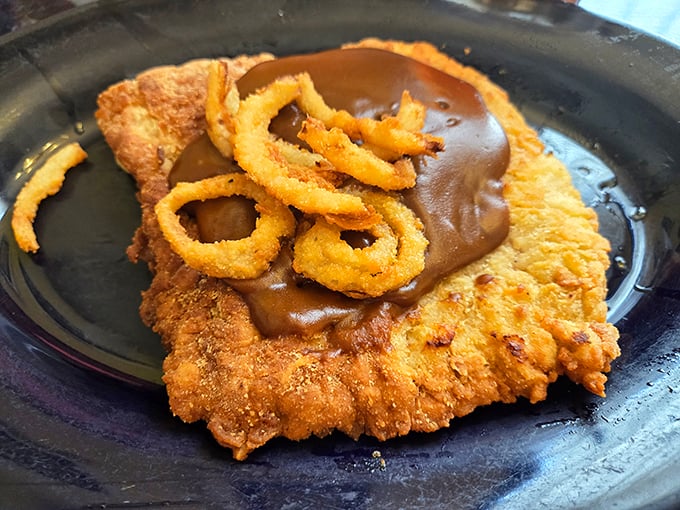 This isn't just a pork tenderloin—it's an Indiana tradition elevated with savory gravy and crispy onion rings. Comfort food that spans generations.