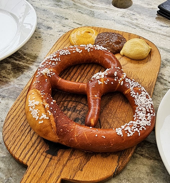 The Bavarian pretzel arrives like an edible work of art – perfectly twisted, gloriously bronzed, and sprinkled with salt crystals that catch the light.
