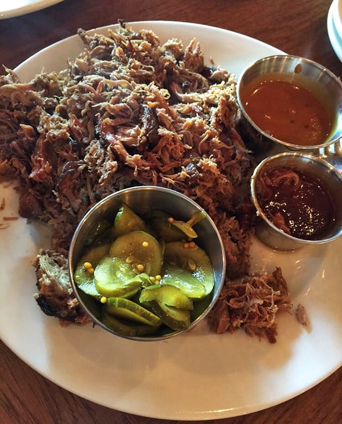 Pulled pork piled high with pickles and sauce – the kind of plate that makes vegetarians question their life choices.