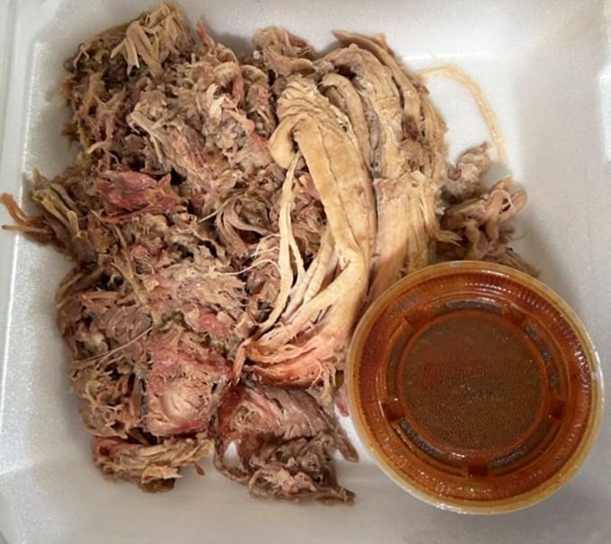 Pulled pork that's been coaxed into surrender after hours in the smoker, ready to be enjoyed with or without sauce—though that sauce is liquid gold.