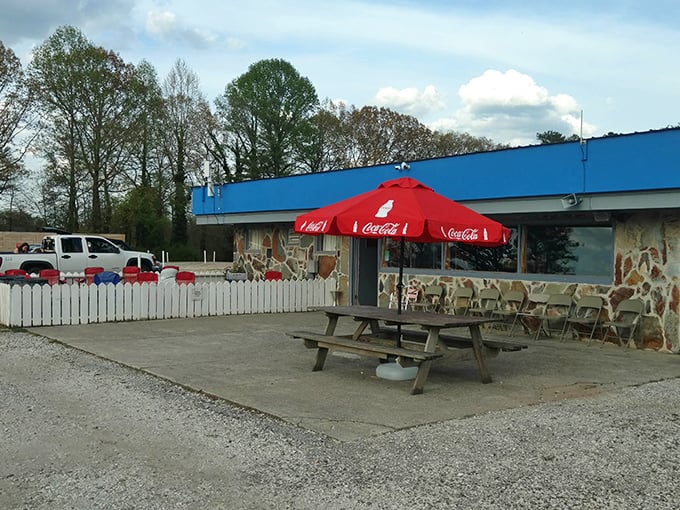 The concession stand, with its stone facade and Coca-Cola umbrella, serves as the beating heart of the drive-in experience—fueling both nostalgia and hunger.