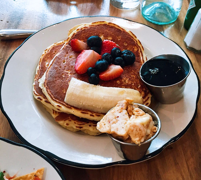 Pancakes that deserve their own Instagram account – golden, fluffy discs of joy accompanied by fresh berries that pop like edible jewels.