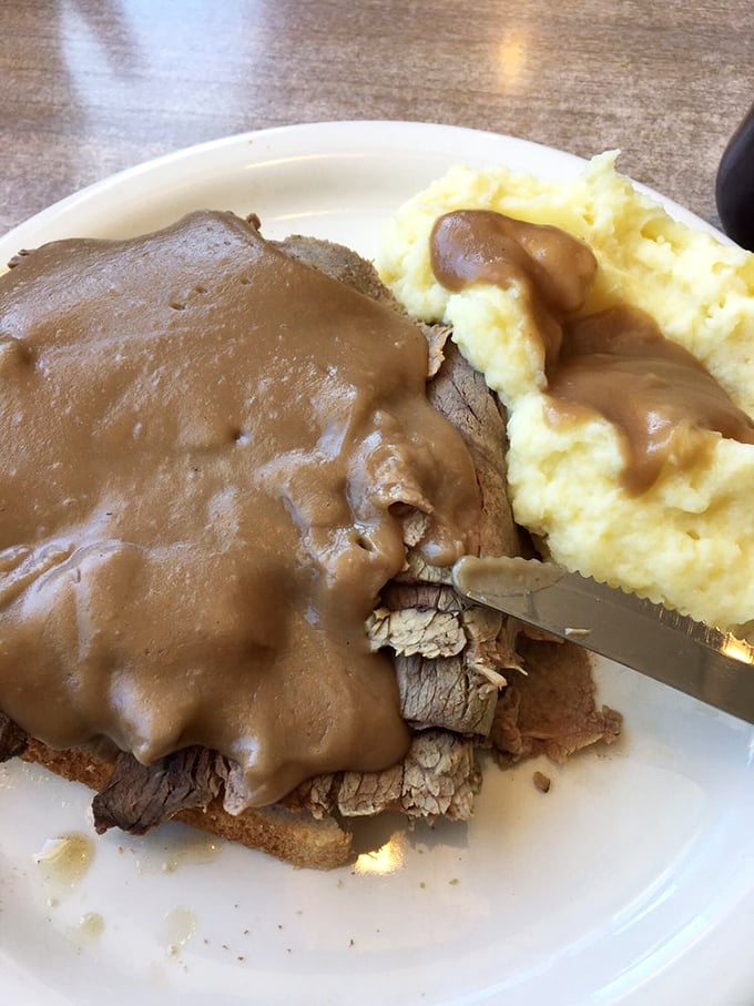 The roast beef sandwich—tender, juicy meat smothered in gravy that could make cardboard taste delicious, alongside mashed potatoes that clearly never came from a box.