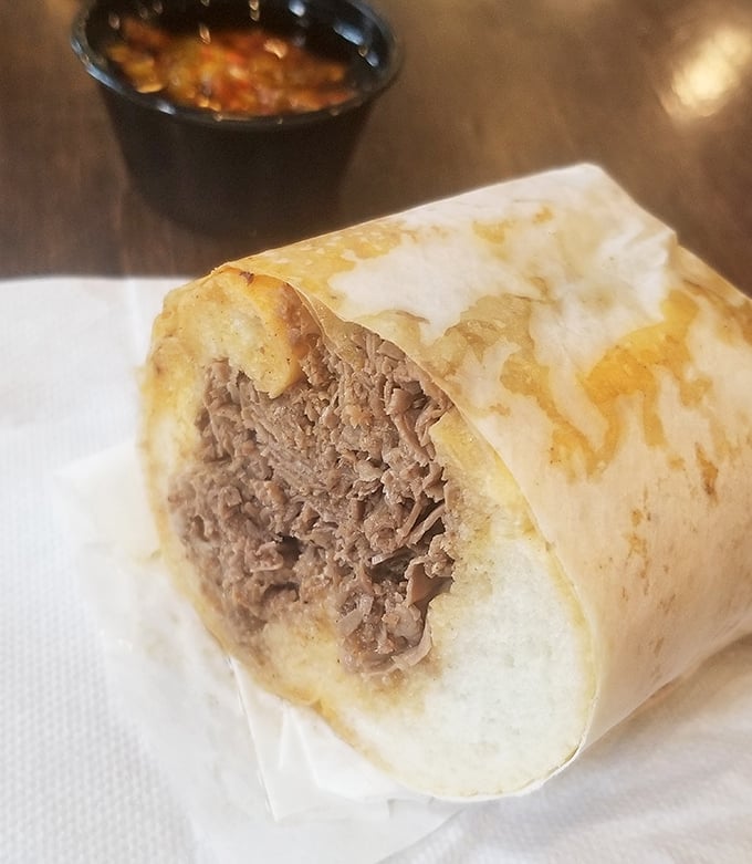 The Italian beef, stripped down to its essence – thinly sliced, perfectly seasoned meat cradled in bread that's somehow both sturdy and yielding. Poetry in sandwich form.