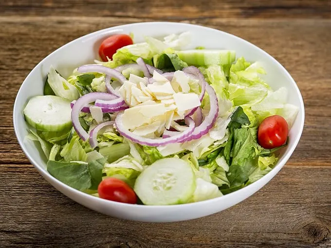 The house salad—that moment of green virtue before diving headfirst into a sea of delicious carbs.