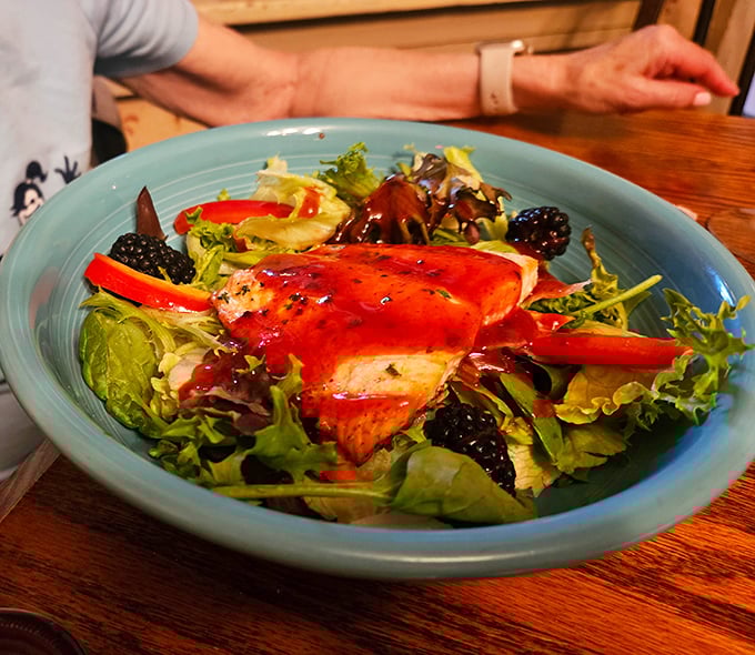 A salmon salad that proves healthy eating doesn't have to be punishment – vibrant greens, fresh berries, and perfectly cooked fish in harmonious balance.