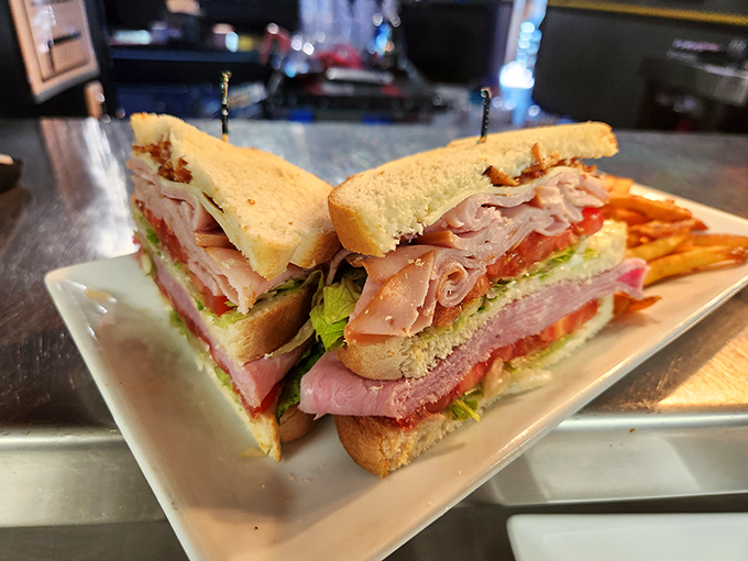 The club sandwich – mankind's greatest architectural achievement involving bread, meat, and toothpicks – served with a side of golden fries.