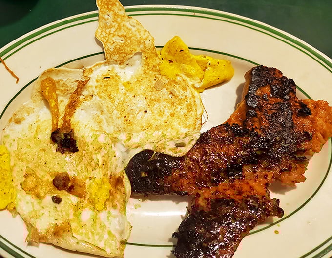 The holy breakfast trinity – perfectly cooked eggs, bacon with that ideal crisp-to-chew ratio, and home fries that deserve their own fan club.